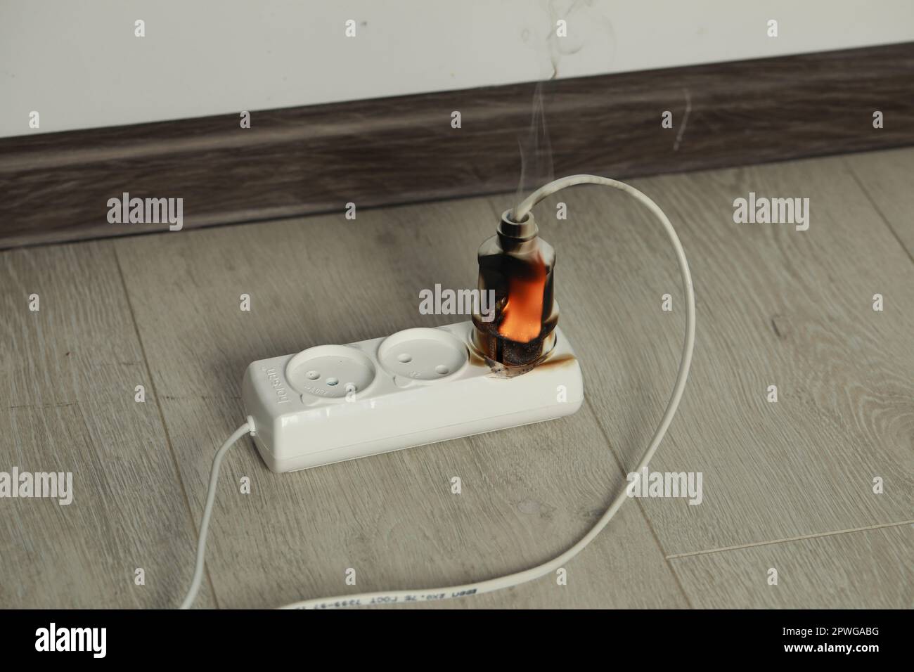 Inflamed plug in power strip indoors. Electrical short circuit Stock ...