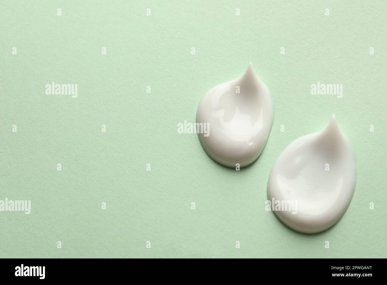 Samples of face cream on light green background, flat lay. Space for ...