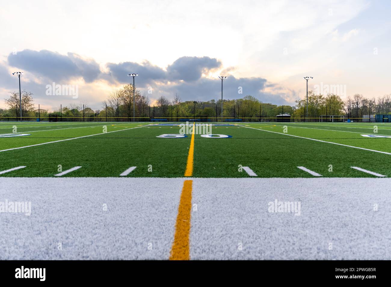 Dramatic late afternoon photo of the 50 yard line on a synthetic turf ...