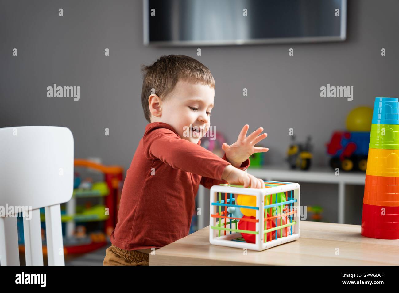 A cute little toddler boy of two years old plays with multi-colored ...