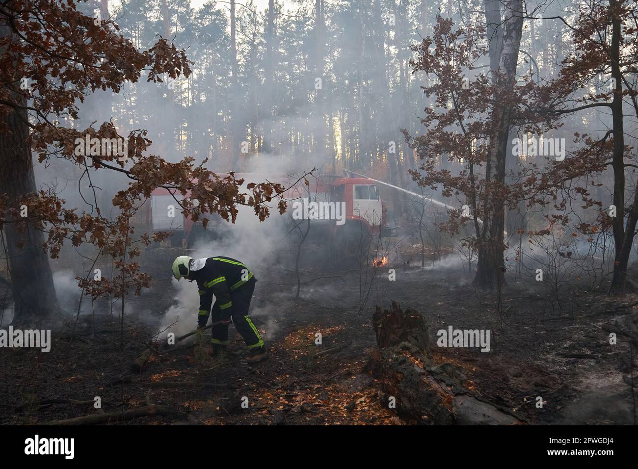 firefighters spray water to wildfire. Fireman working hard to put out ... firefighters spray water to wildfire. Fireman working hard to put out ...