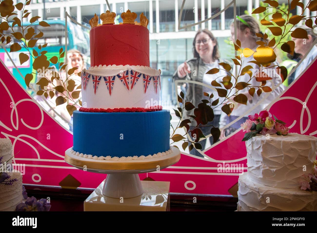 London, UK. 30th Apr 2023. People admire a coronation cake in a shop ...