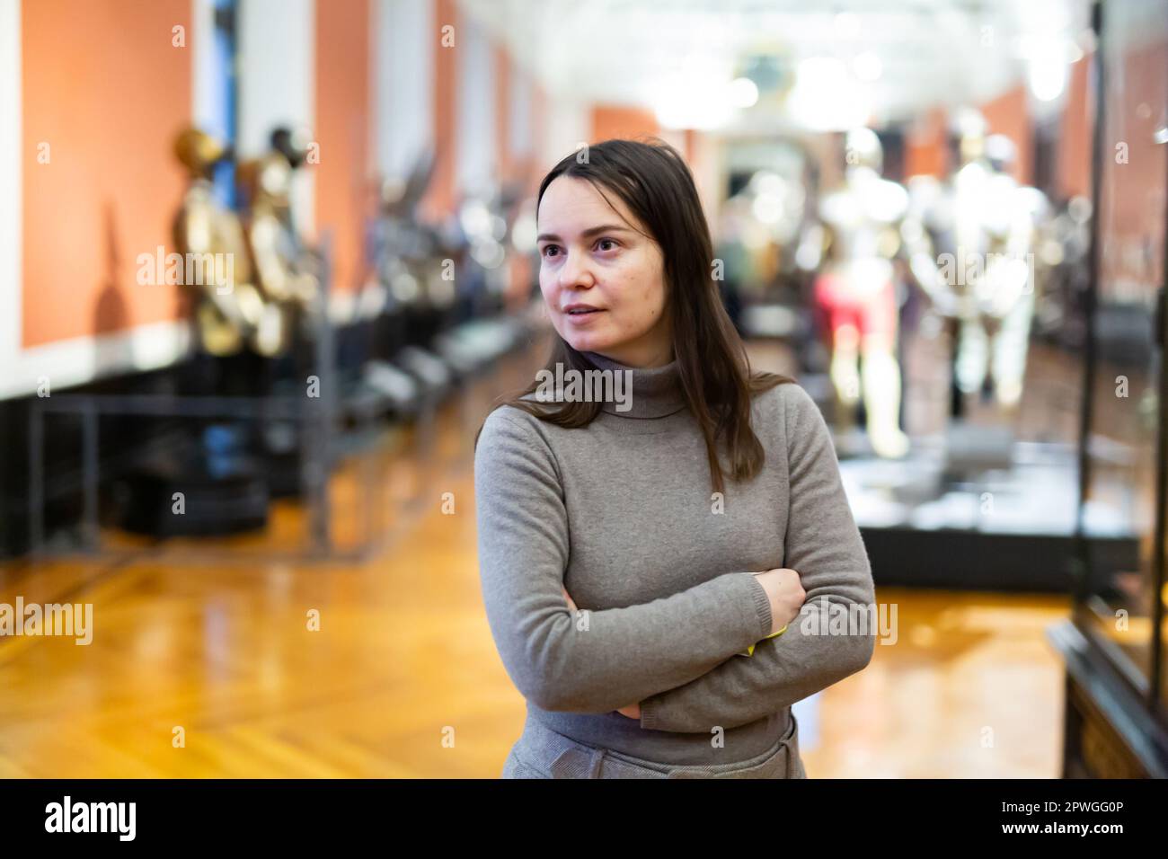 Female museum visitor examining with interest ancient armor Stock Photo ...