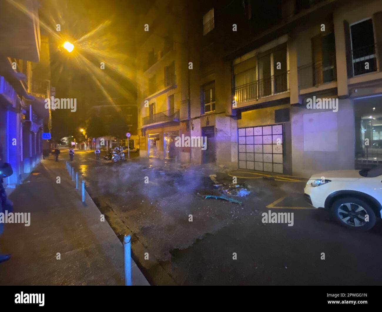 Smoke on the street on a night urban scene with riots and fires and ...