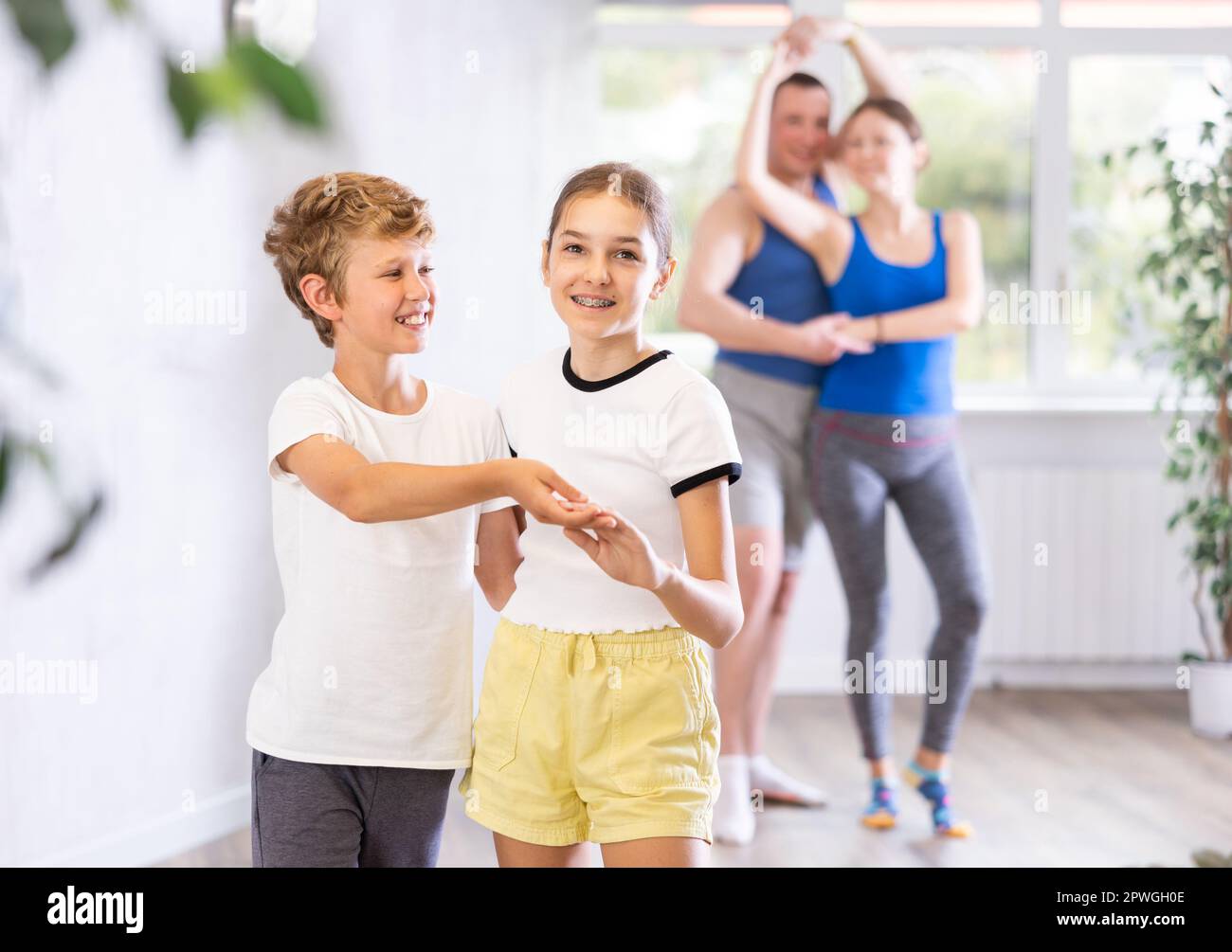 Happy preteen boy and girl practicing dance in pairs together with ...
