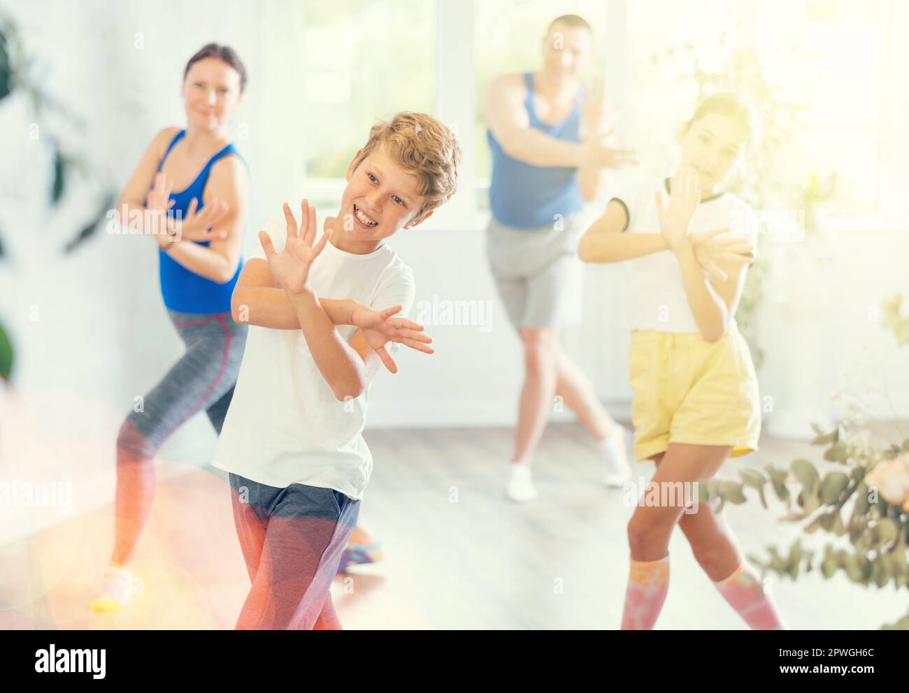 Happy preteen boy practicing dance movements with his family Stock ...