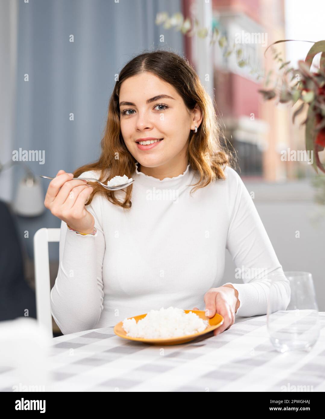 Emotional young woman eating rice at home Stock Photo - Alamy