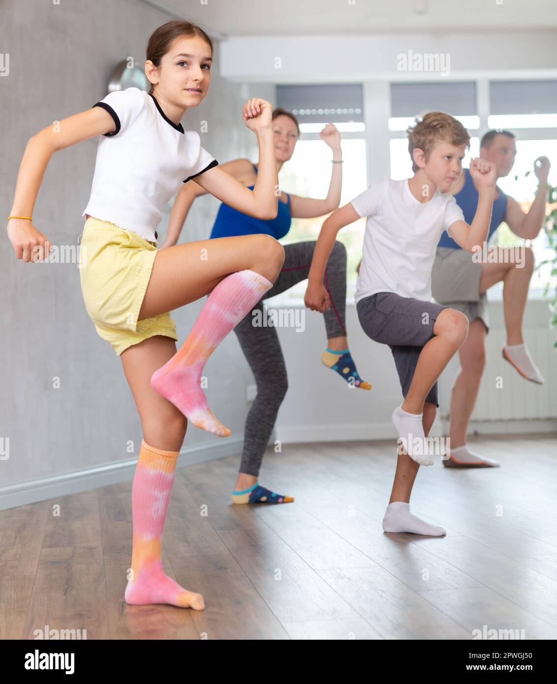 family learning dynamic boogie woogie in pair in dance studio during ...