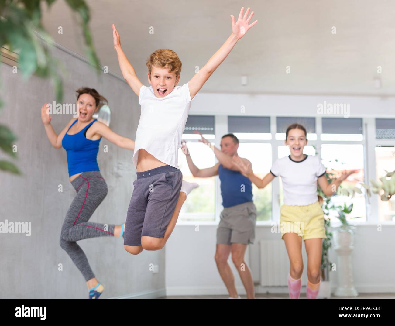 Happy family with son and daughter jumping in gym Stock Photo - Alamy
