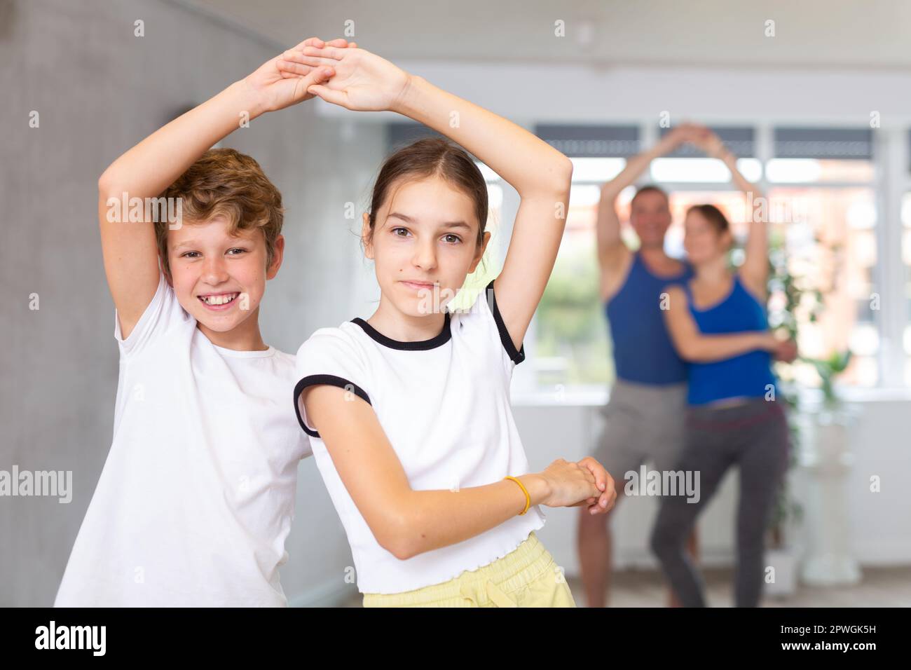 Boy and girl dancing salsa in studio during group training Stock Photo ...