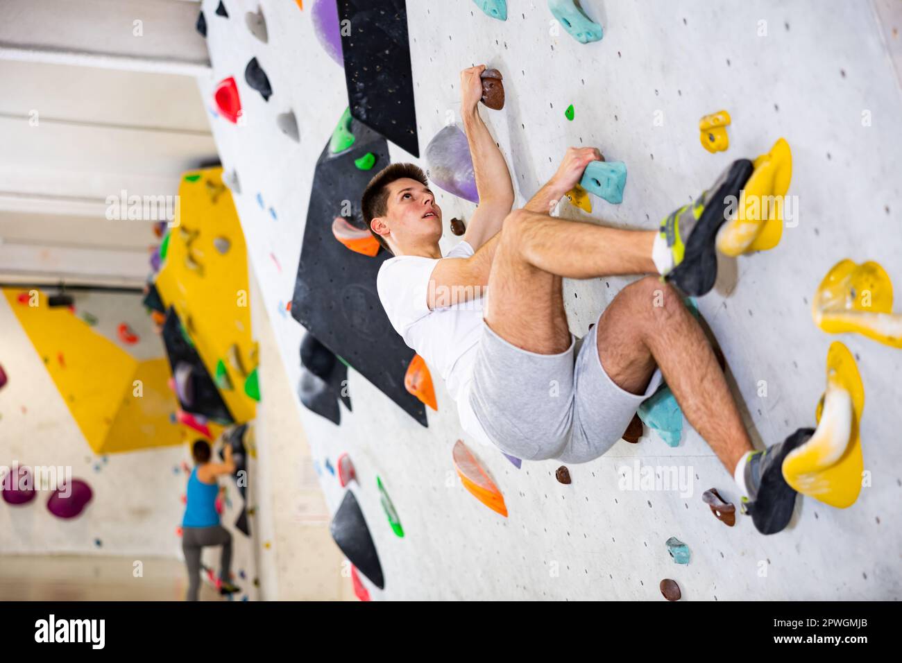 Male mountaineer climbing artificial rock wall without his belay ...