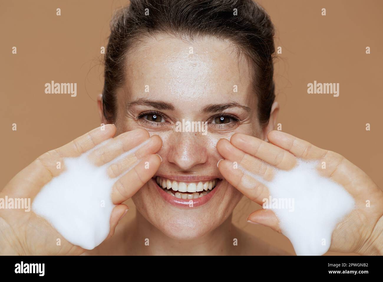 Happy Modern 40 Years Old Woman With Foaming Facial Cleanser Washing