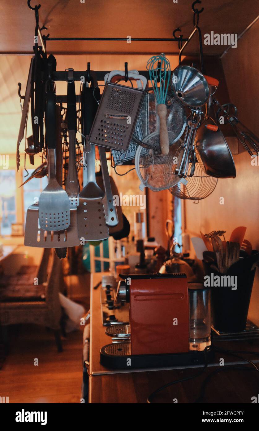 detail of a steel kitchenware hanging in modern kitchen, mixed light ...