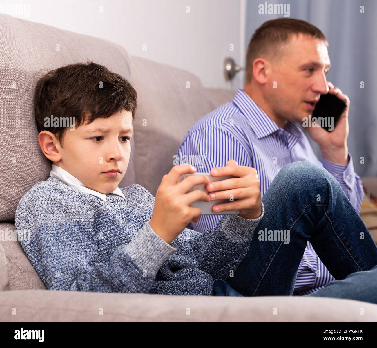 Focused boy with phone Stock Photo - Alamy
