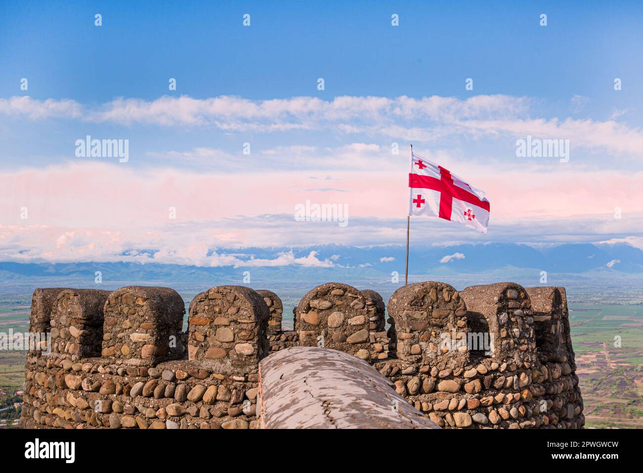 The flag of Georgia waving on bright blue sky background on Sighnaghi ...