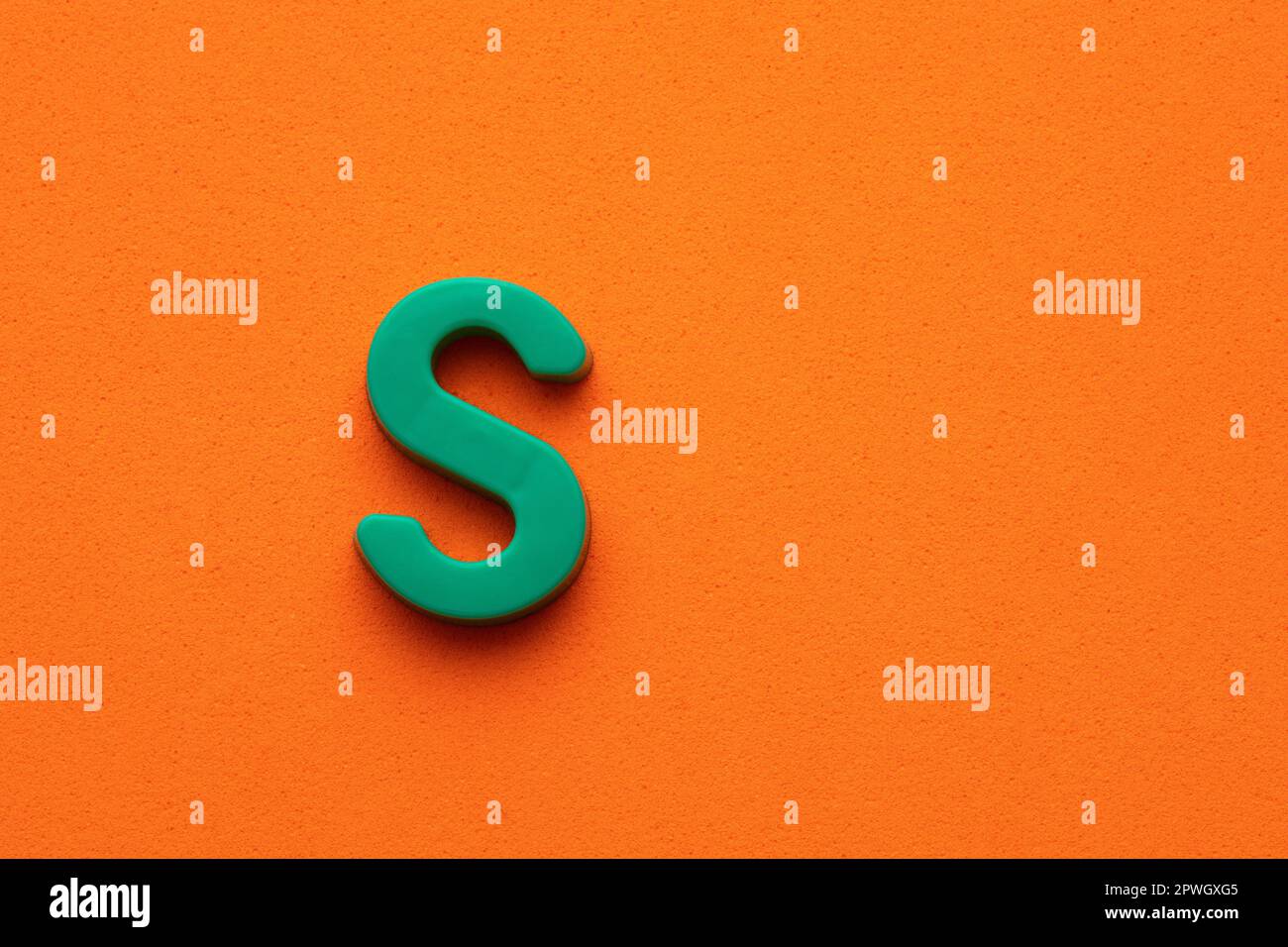 Letter S green plastic uppercase on orange foamy background Stock Photo ...