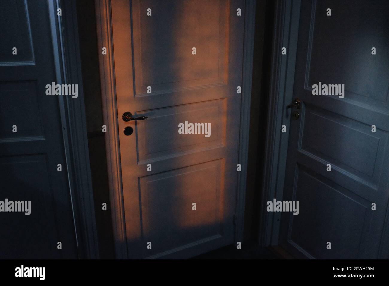 hallway, three closed doors with atmospheric light at night Stock Photo ...