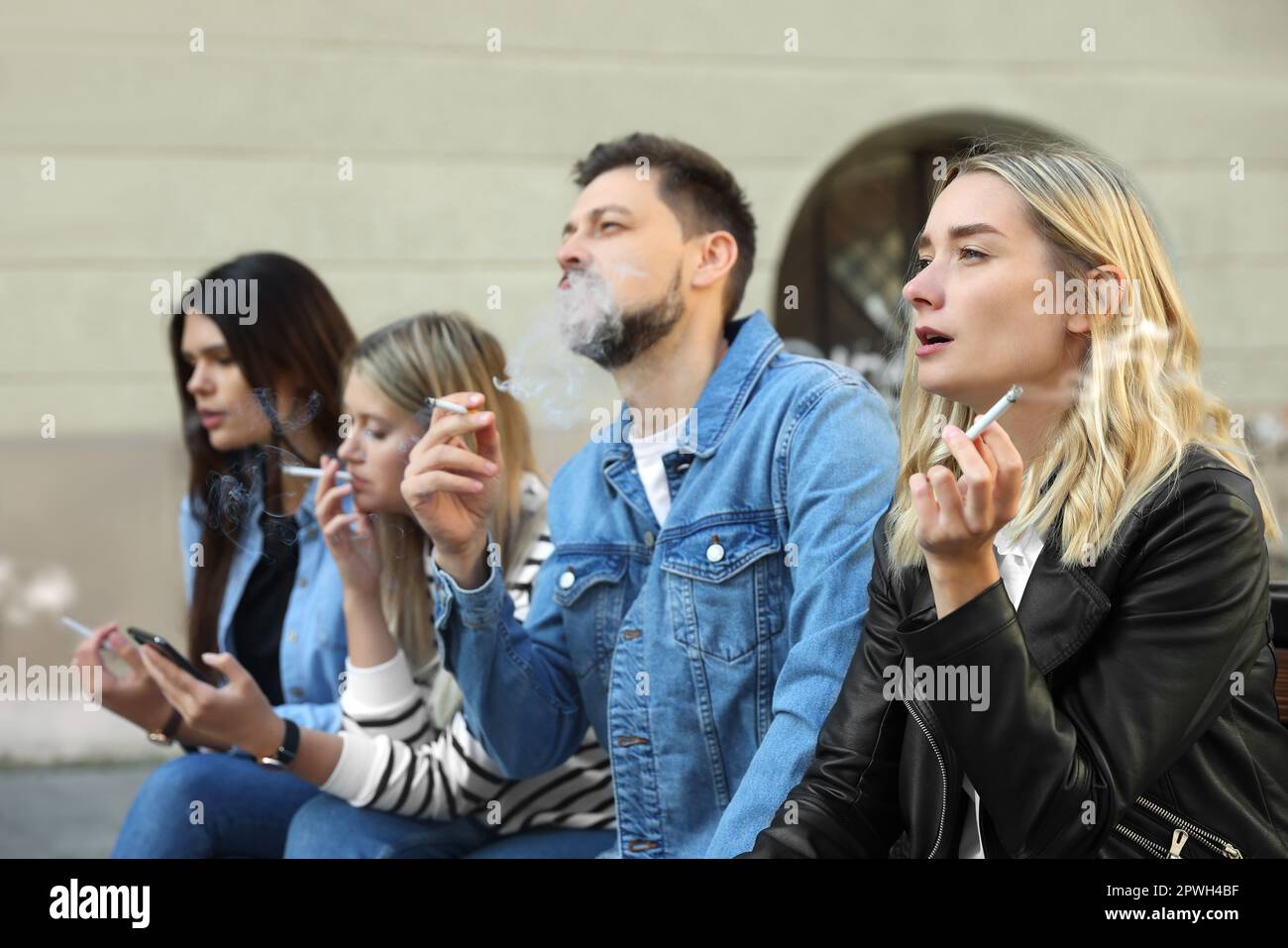 People smoking cigarettes at public place outdoors Stock Photo - Alamy