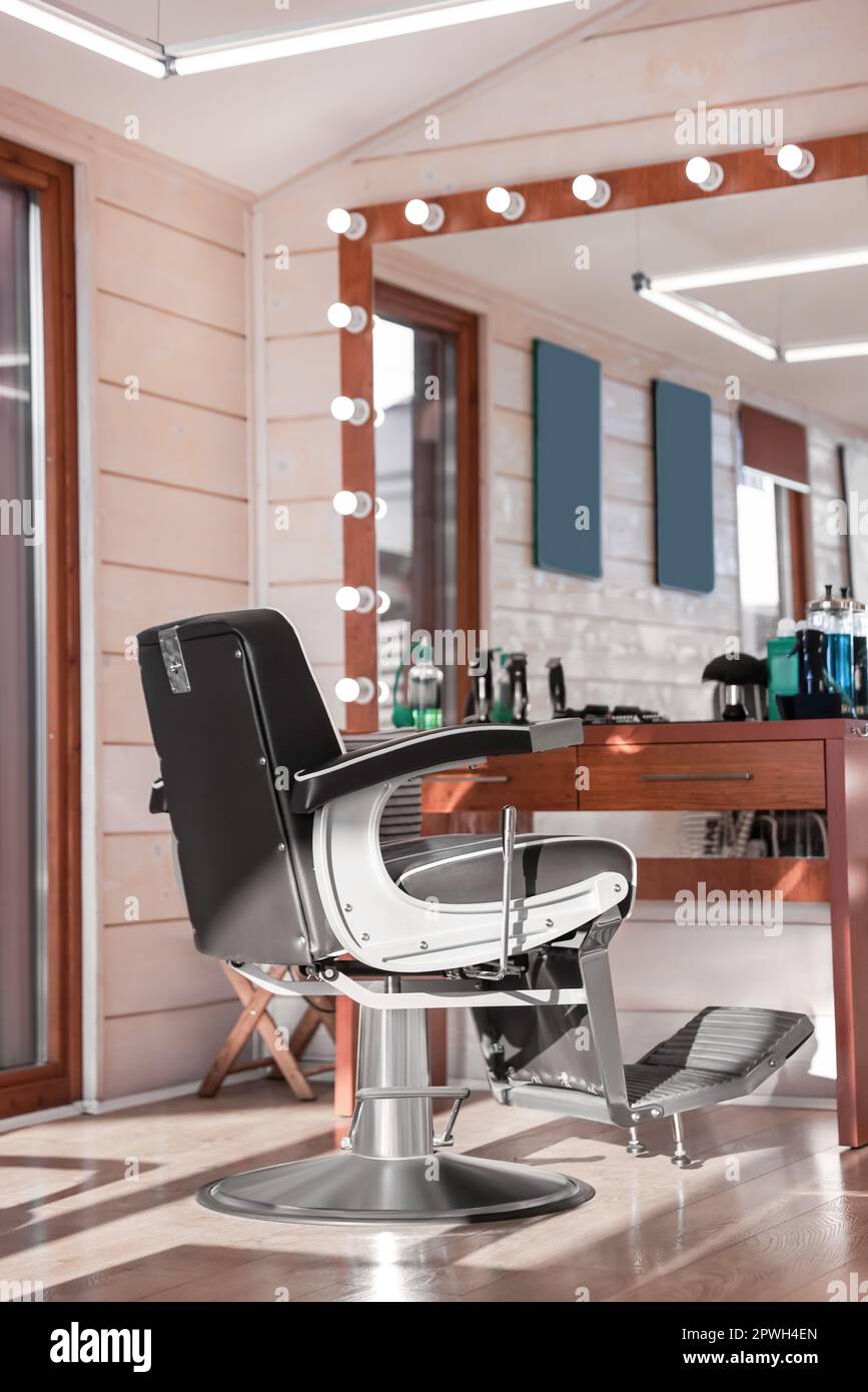 Stylish hairdresser's workplace with professional armchair in ...