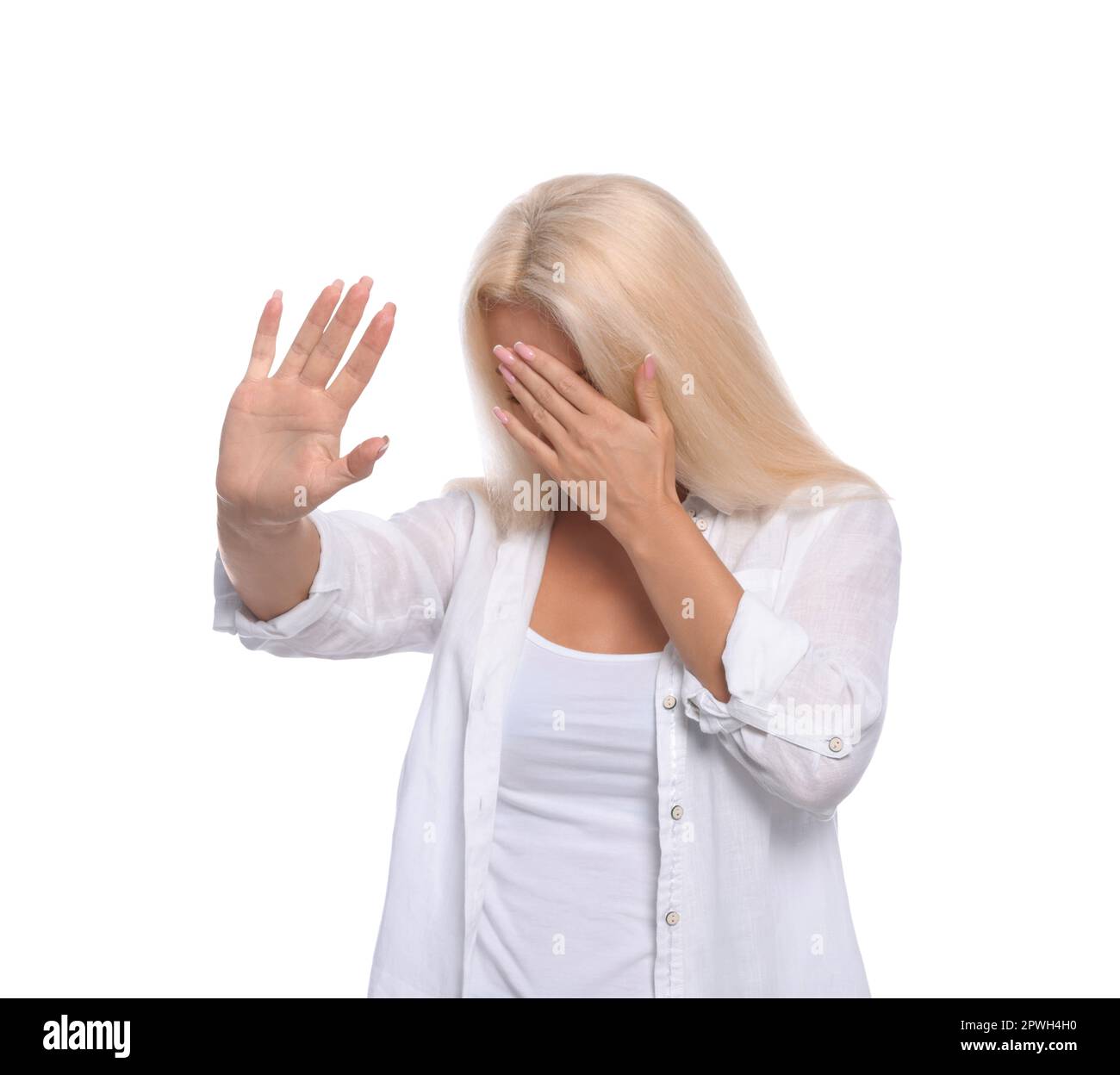 Embarrassed woman covering face with hand on white background Stock ...