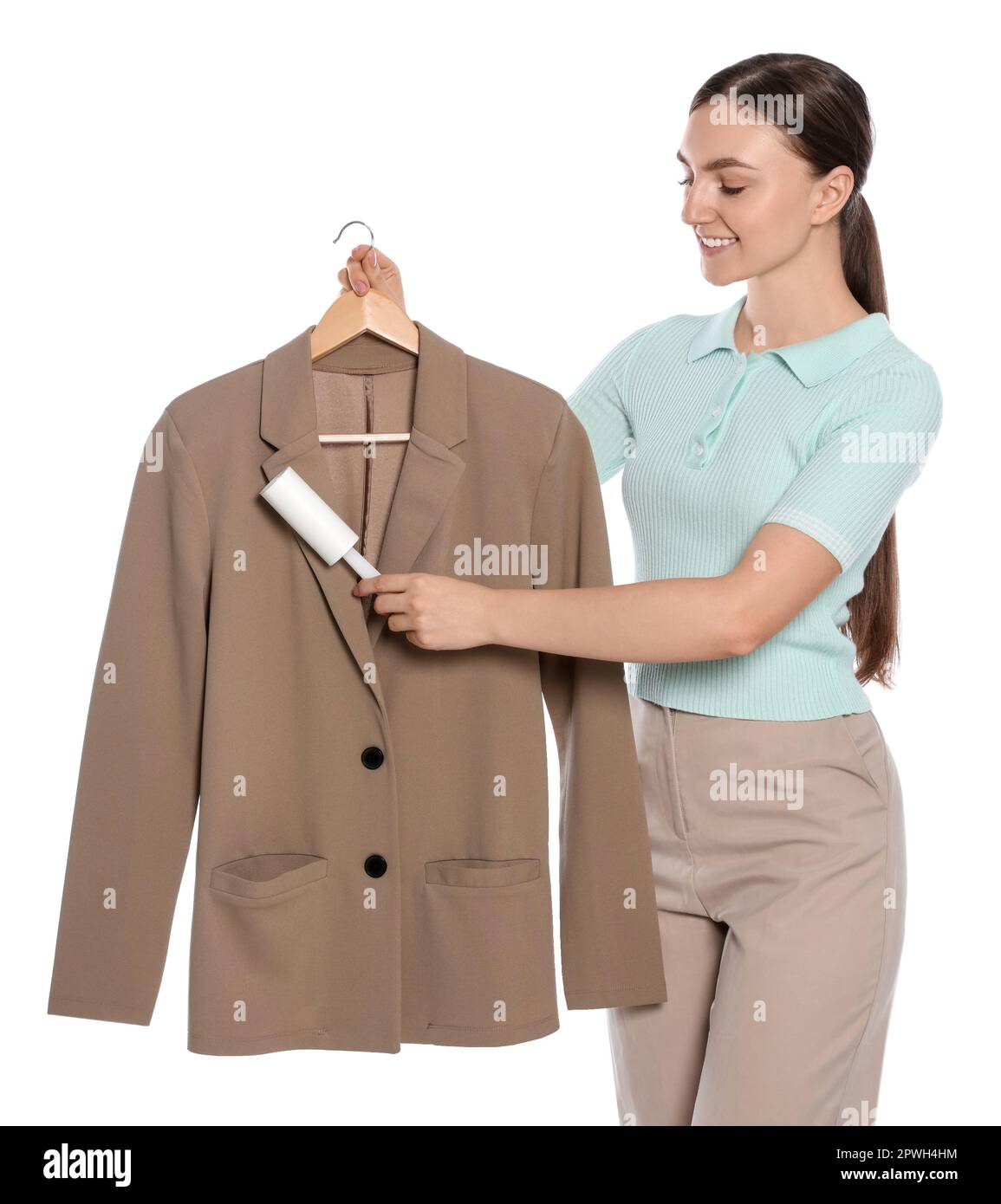 Young woman cleaning suit with lint roller on white background Stock ...