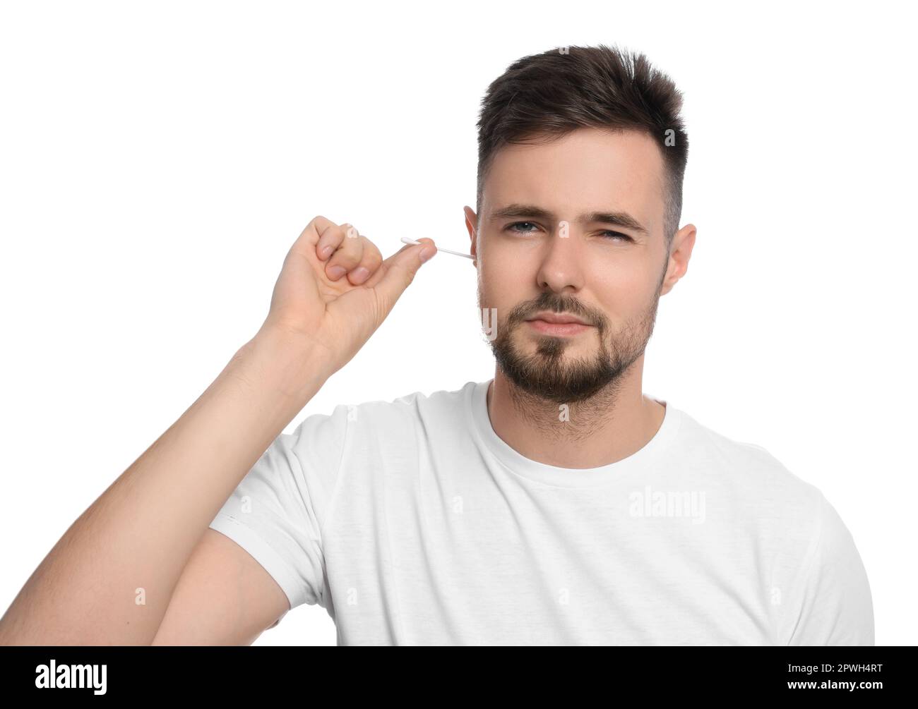 Young man cleaning ear with cotton swab on white background Stock Photo ...