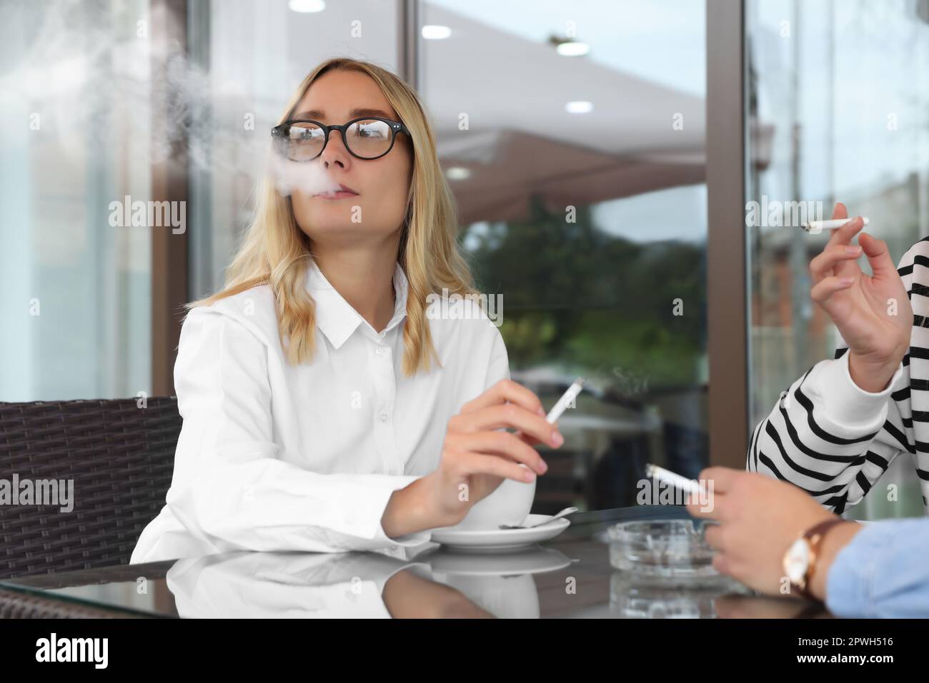 Women smoking at outdoor cafe hi-res stock photography and images - Alamy