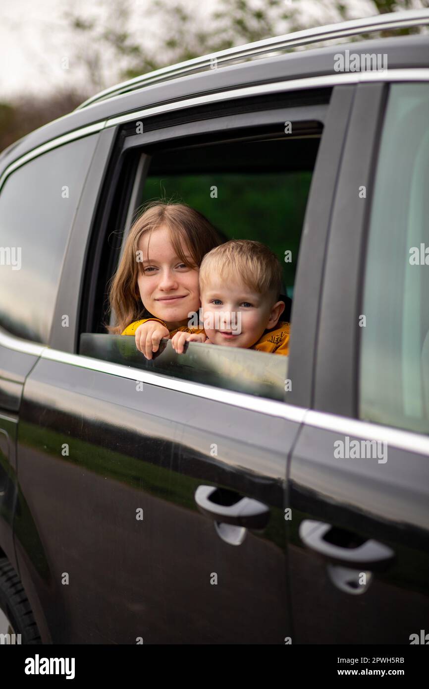 Happy brother and sister looking out car window Stock Photo - Alamy