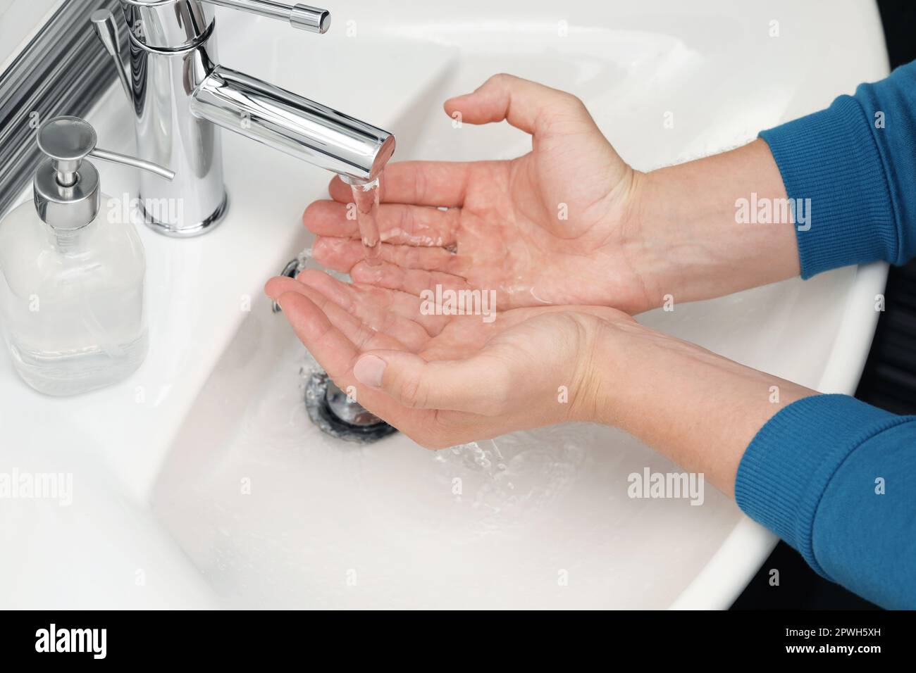 Man using water tap to wash hands in bathroom, closeup Stock Photo - Alamy