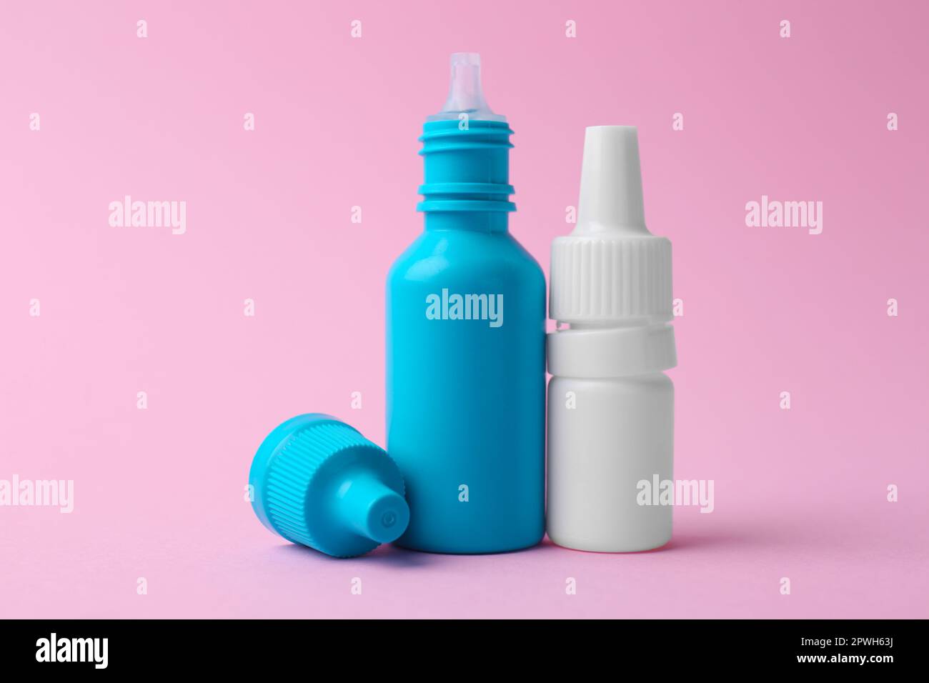 Bottles of medical drops on pink background Stock Photo - Alamy