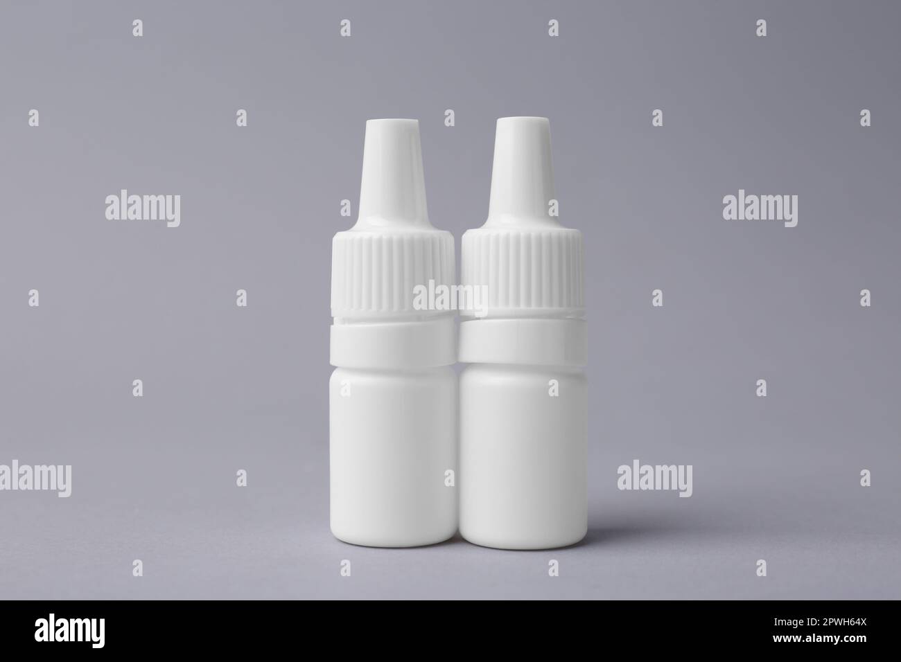 Bottles of medical drops on grey background Stock Photo - Alamy
