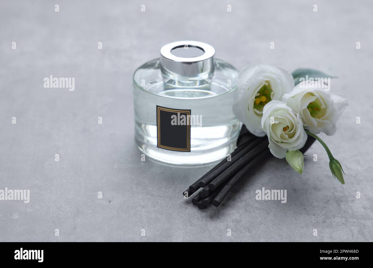 Reed sticks, glass bottle with aromatic liquid and eustoma flowers on ...