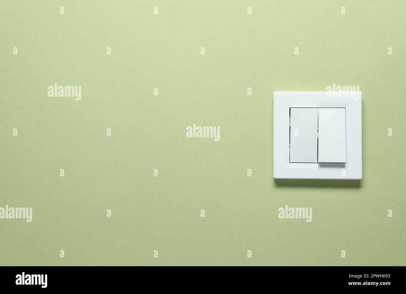 Modern plastic light switch on green background. Space for text Stock ...