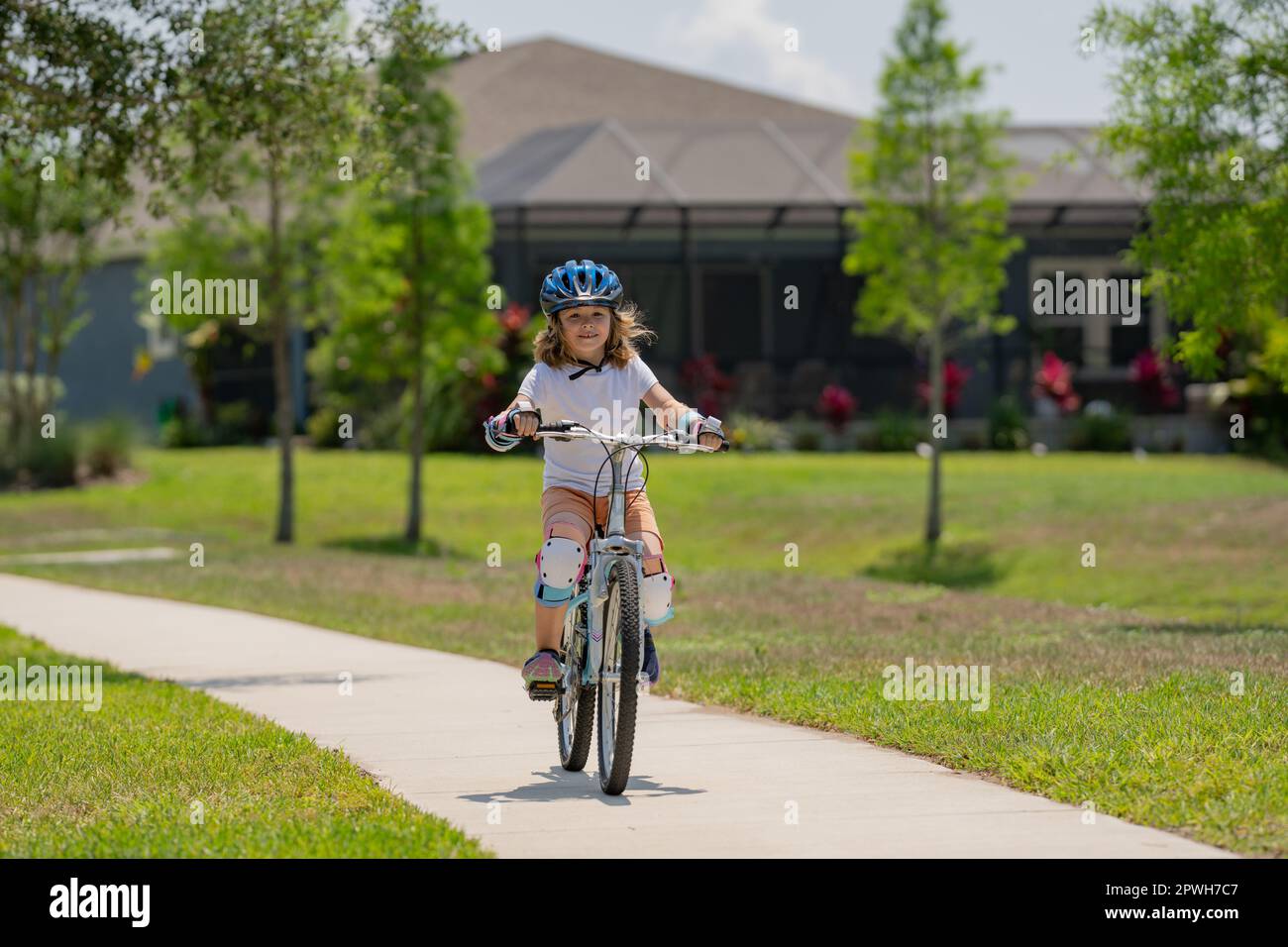 Little kid boy riding a bike in summer park. Children learning to drive ...
