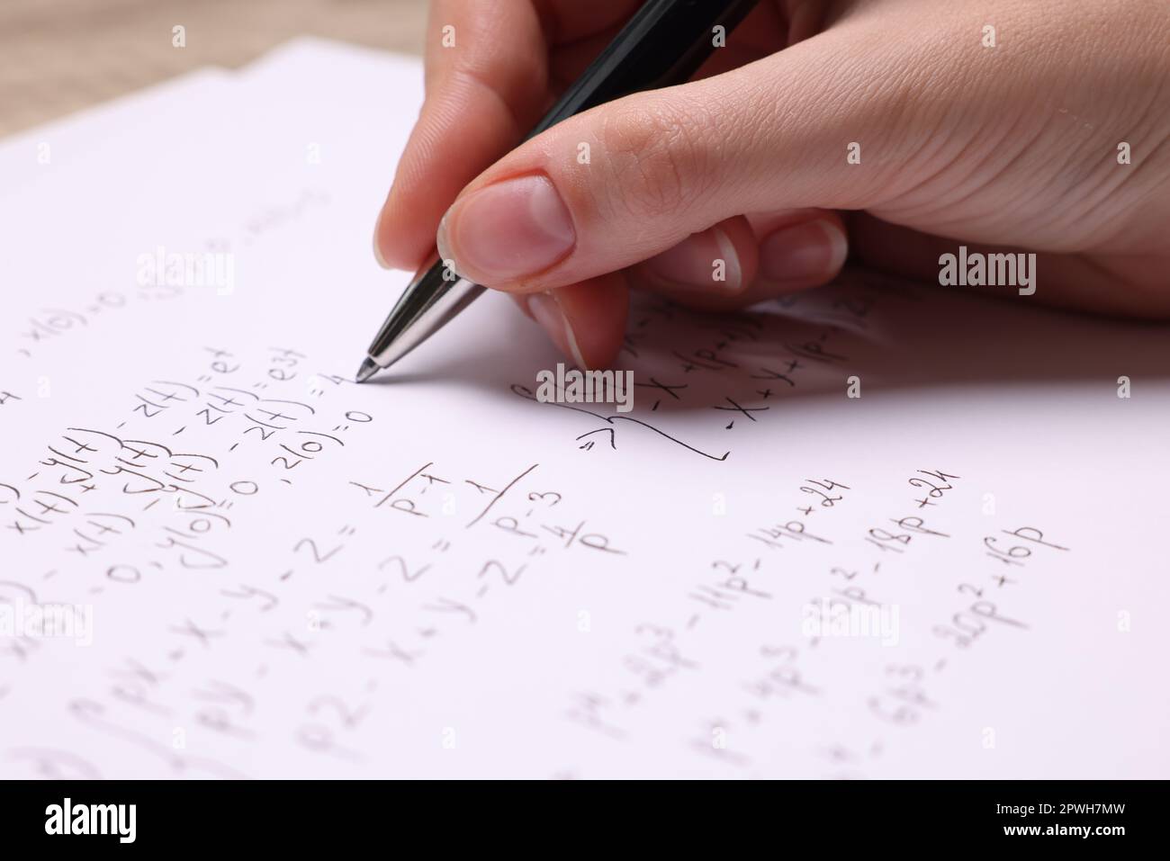 Student writing different mathematical formulas on paper, closeup Stock ...
