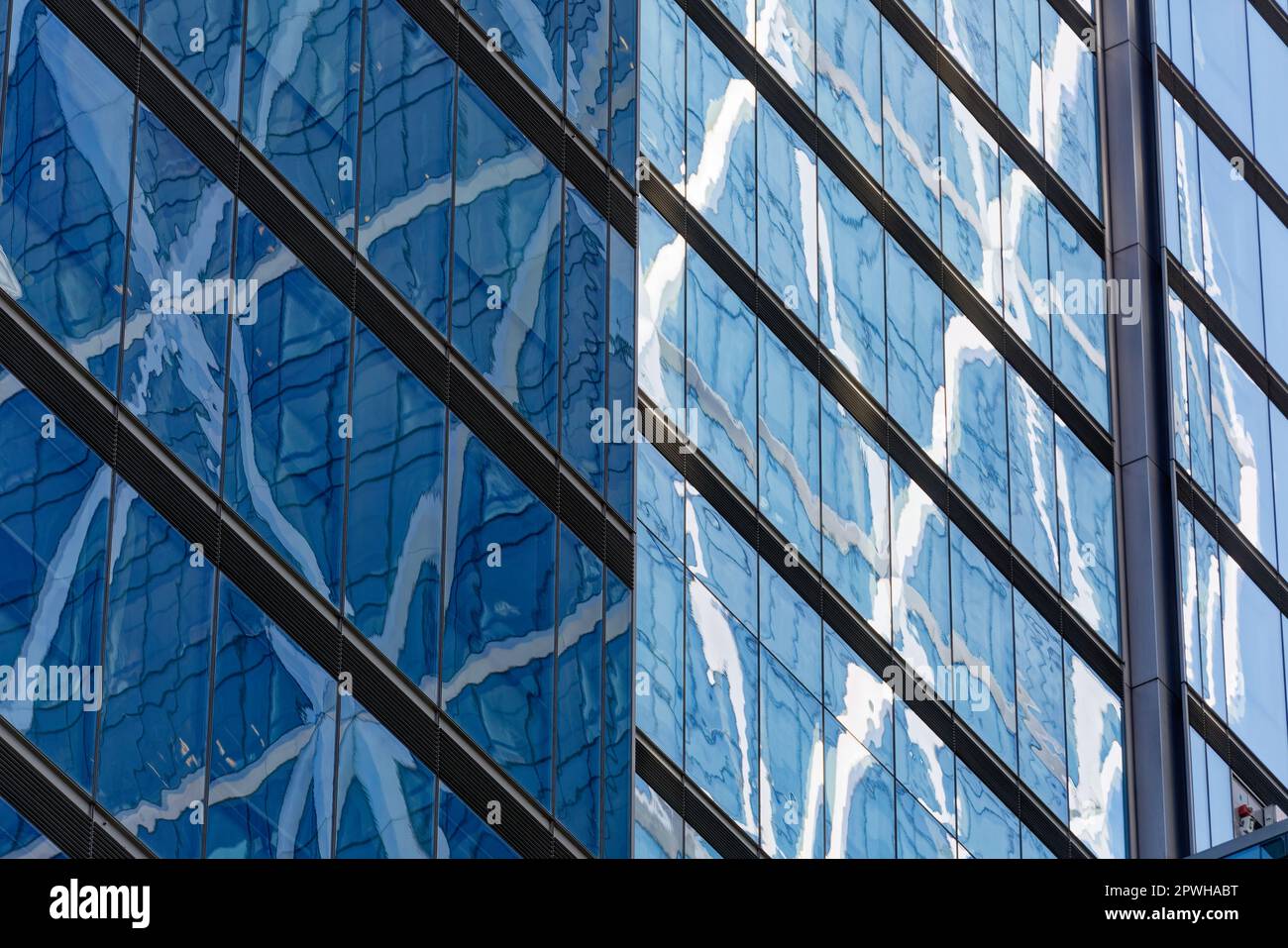 241 West 57th Street, a 1927 masonry office building re-clad in glass curtain wall, reflects ...