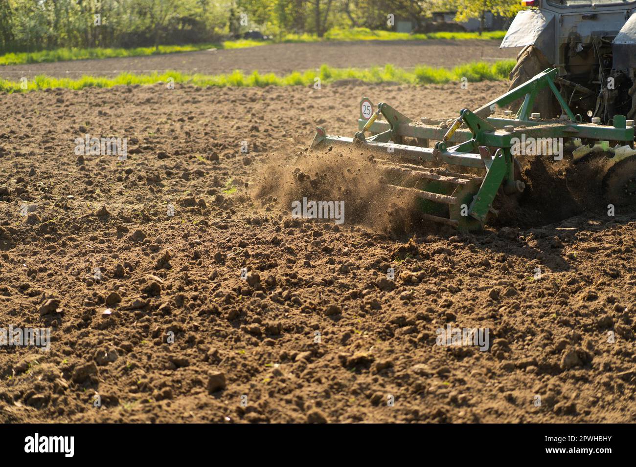 The tractor drives across the field and cultivates the land Stock Photo ...