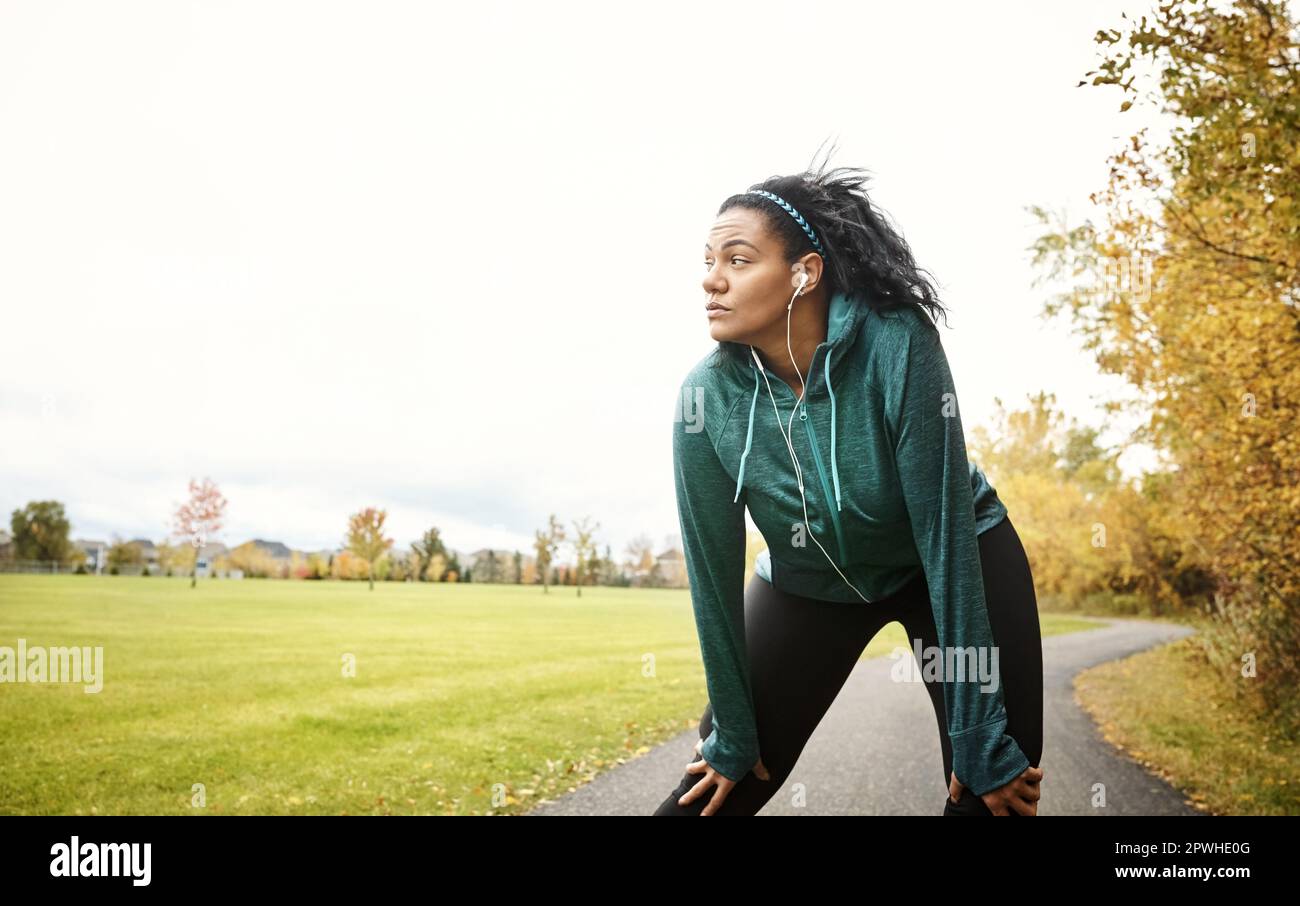 Appreciate any progress. an attractive young woman taking a break while out for a run in nature ...