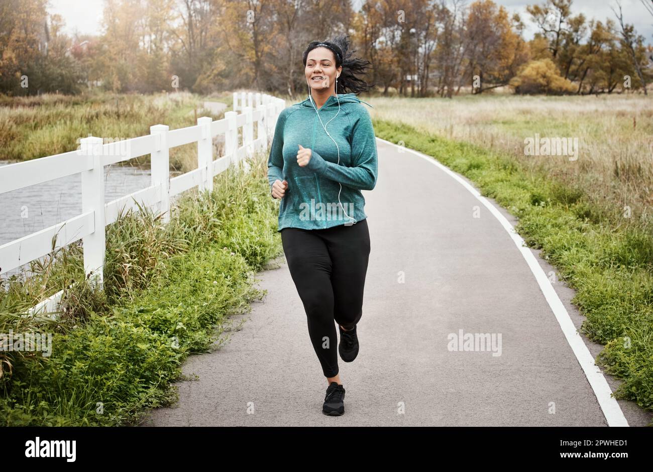 Music keeps her moving. an attractive young woman going for a run in ...