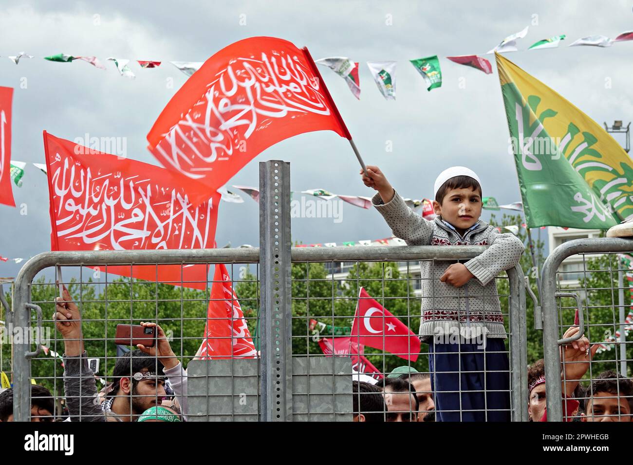 A child seen waving an inscribed flag, "There is no god but Allah ...