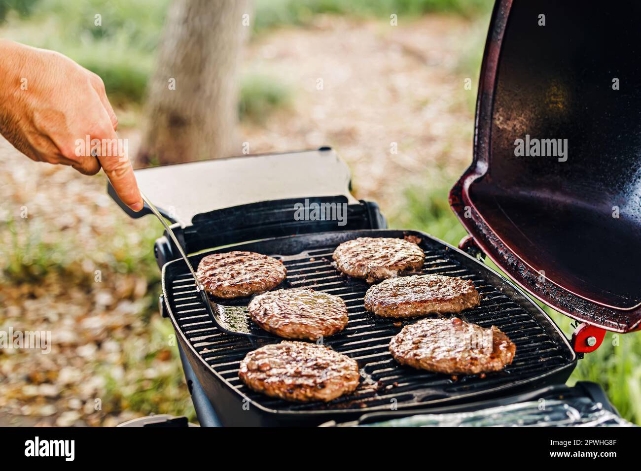 Male hand flipping hamburger meat hi-res stock photography and images ...