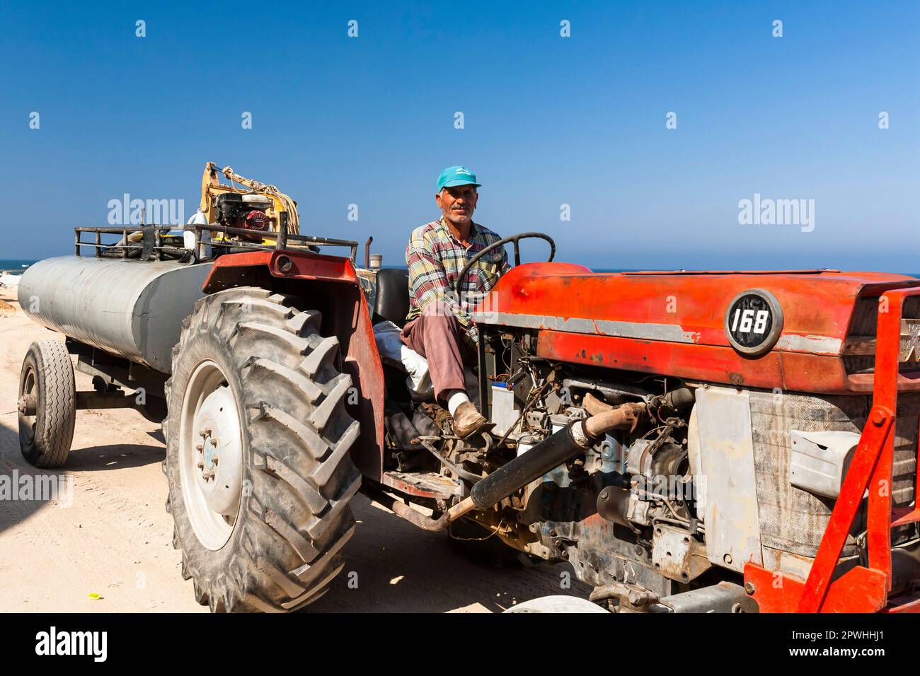 Man driving tractor at ancient Tyre island area, tip of peninsula ...