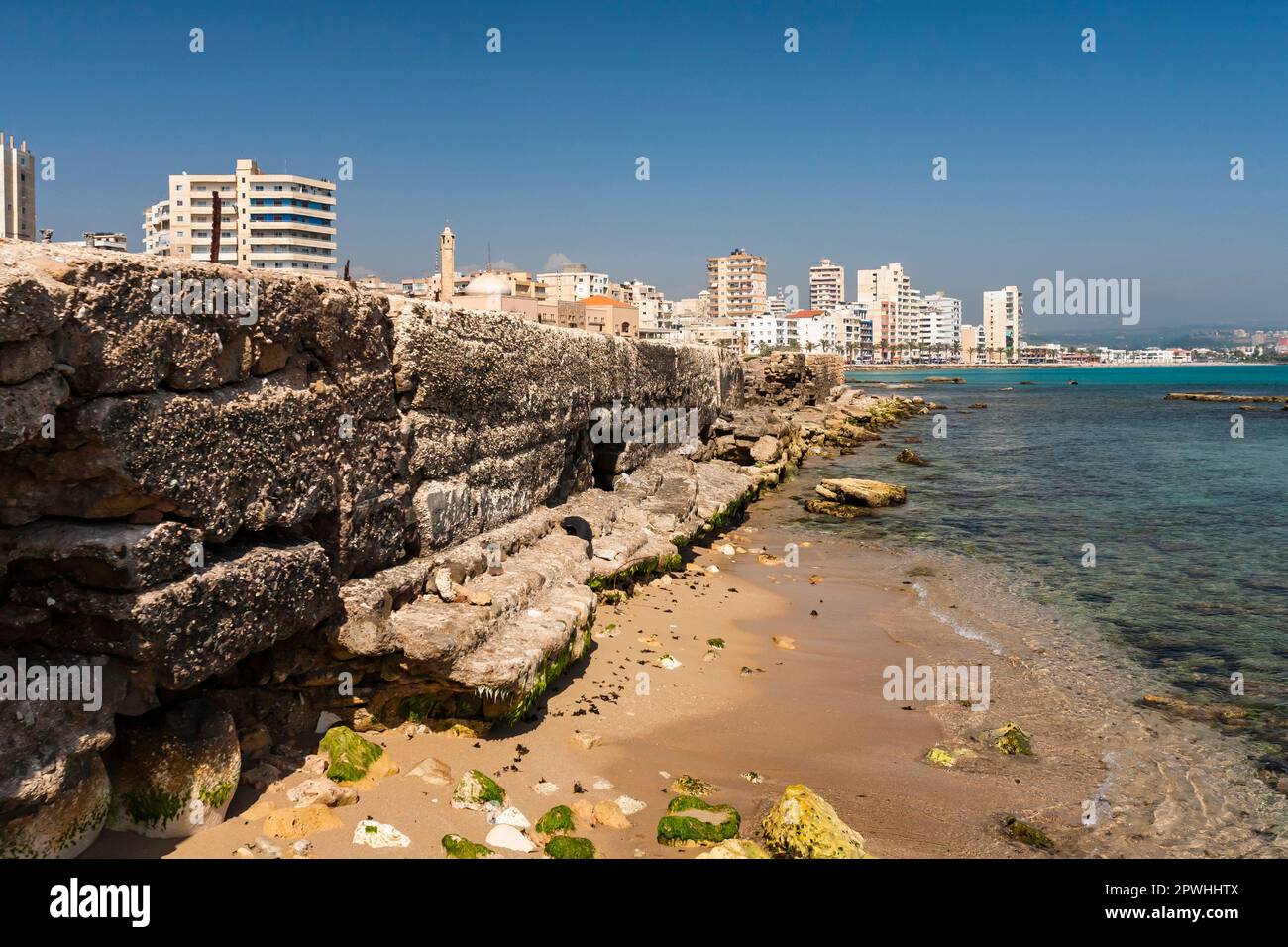 Phoenician city wall at ancient island area, and buildings on courseway ...
