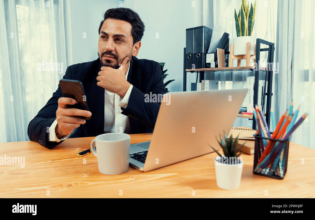 Modern professional businessman at modern office desk using laptop to ...