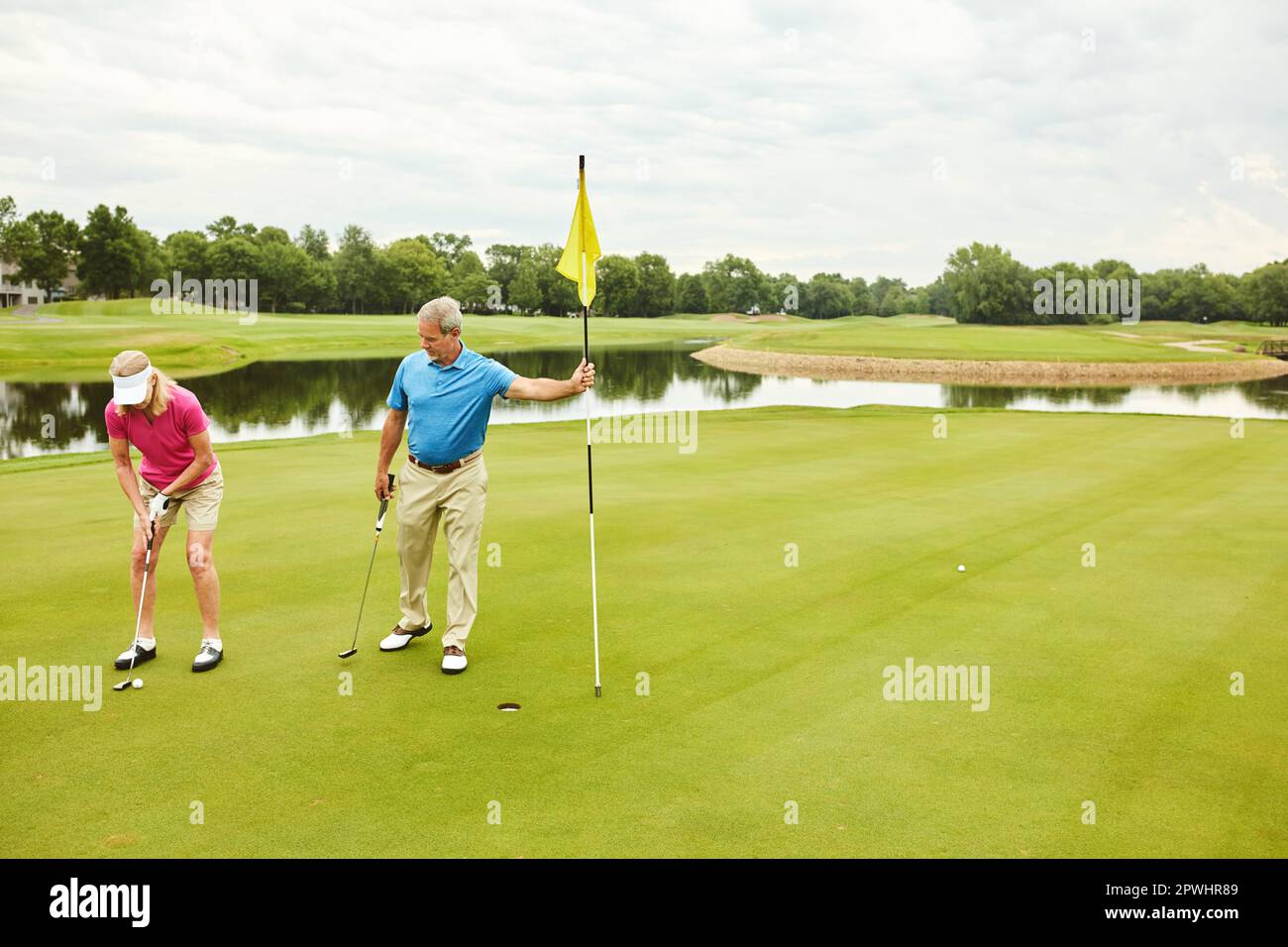 Helping her to perfect her swing. a mature couple out playing golf ...