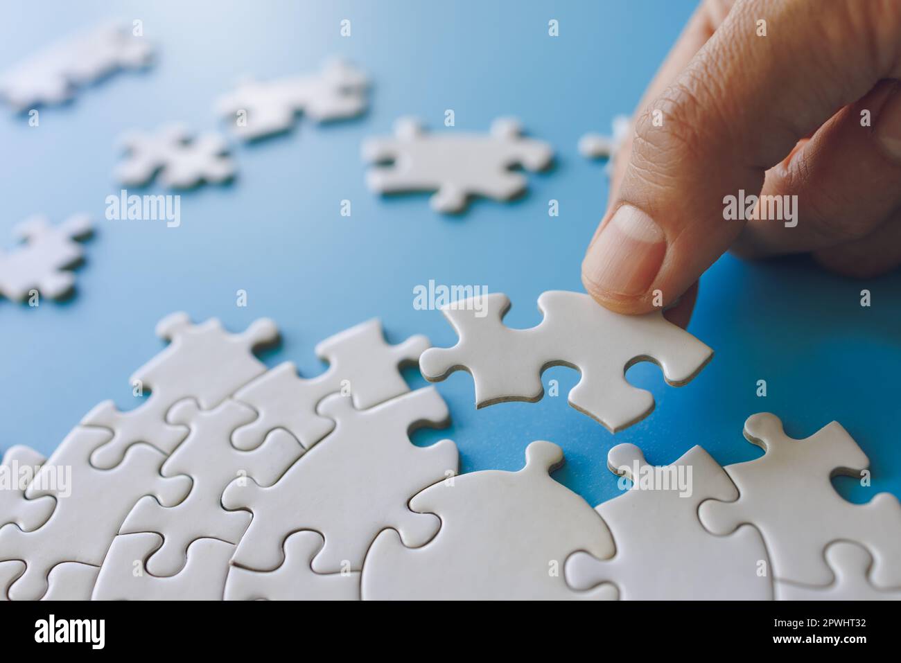 Hand put the last piece of jigsaw puzzle to complete the mission ...