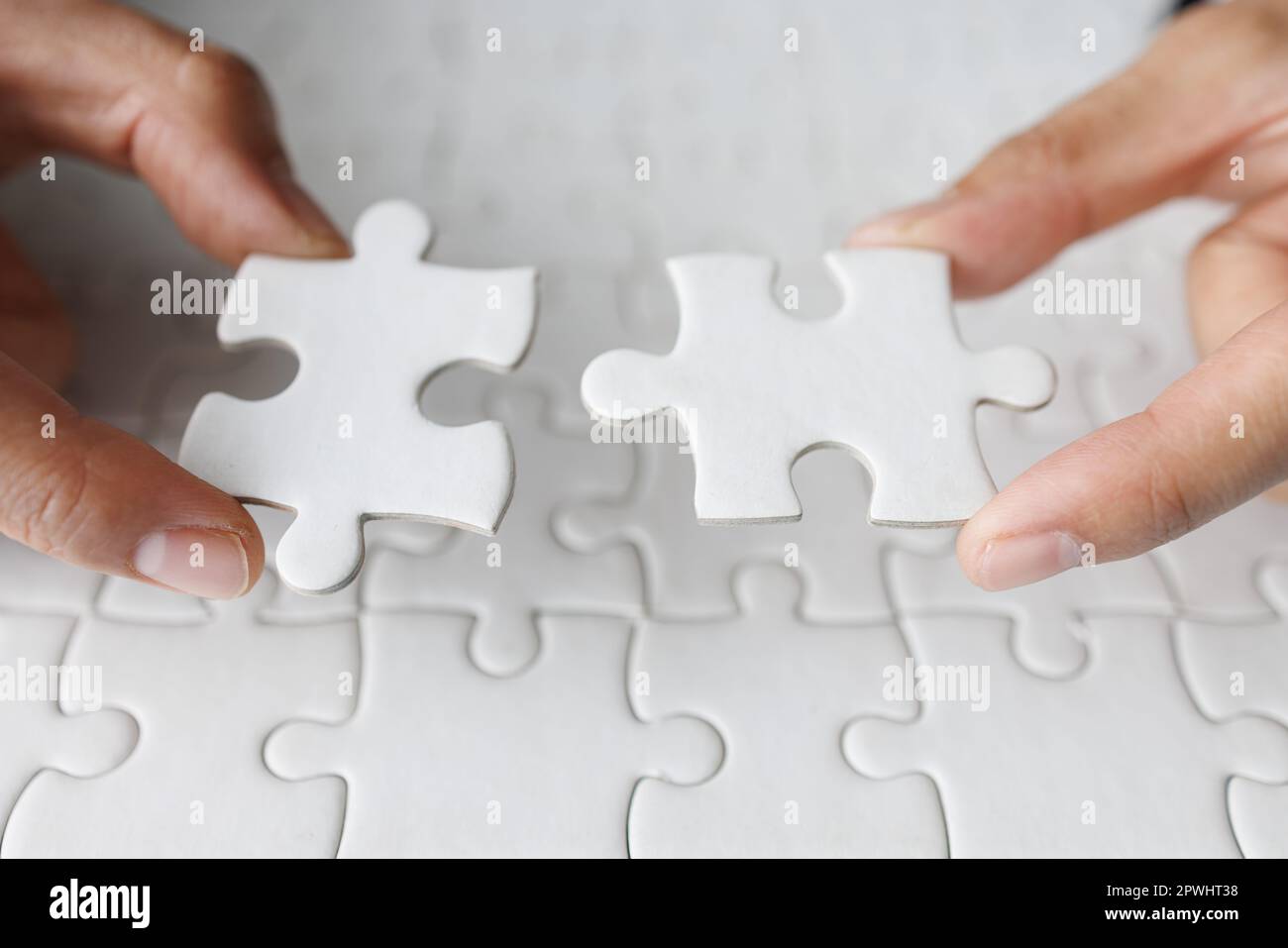 Business woman hand is trying to connect couple White jigsaw puzzle ...