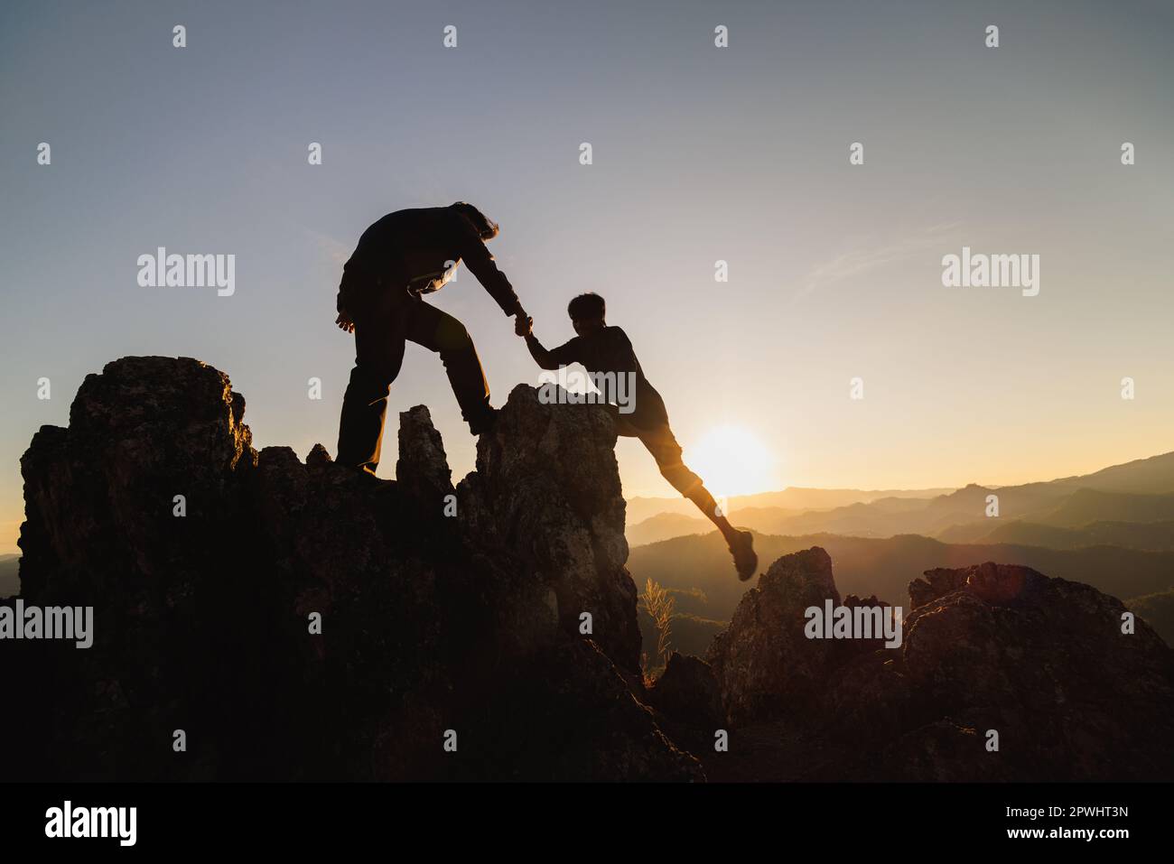 silhouette of Teamwork of two men hiker helping each other on top of ...