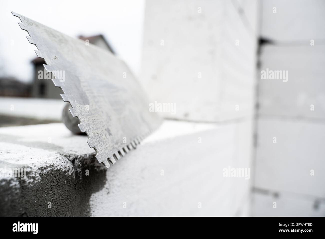 Notched trowel against the background of a building made of aerated ...