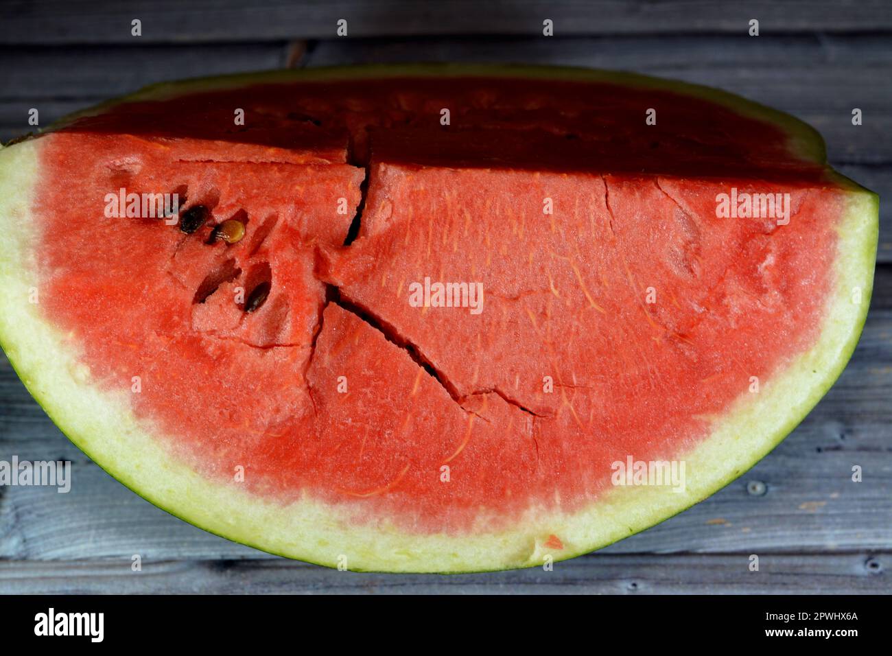 A quarter of watermelon fruit cut piece with seeds and its green shell ...